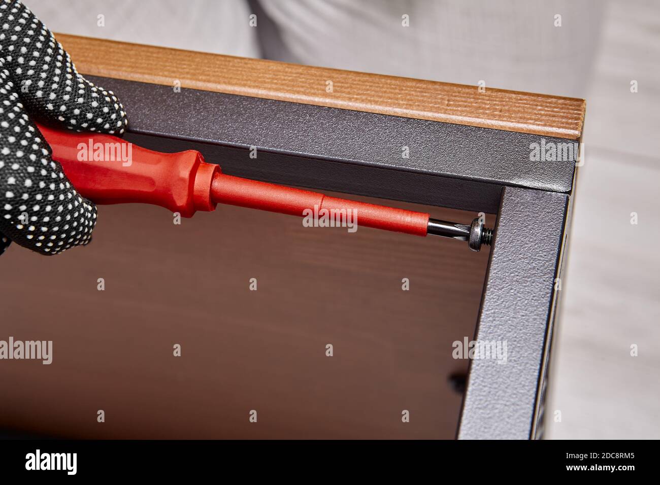 Assembler Is Mounting Metal Tv Stand Using Screwdriver Handyman Is