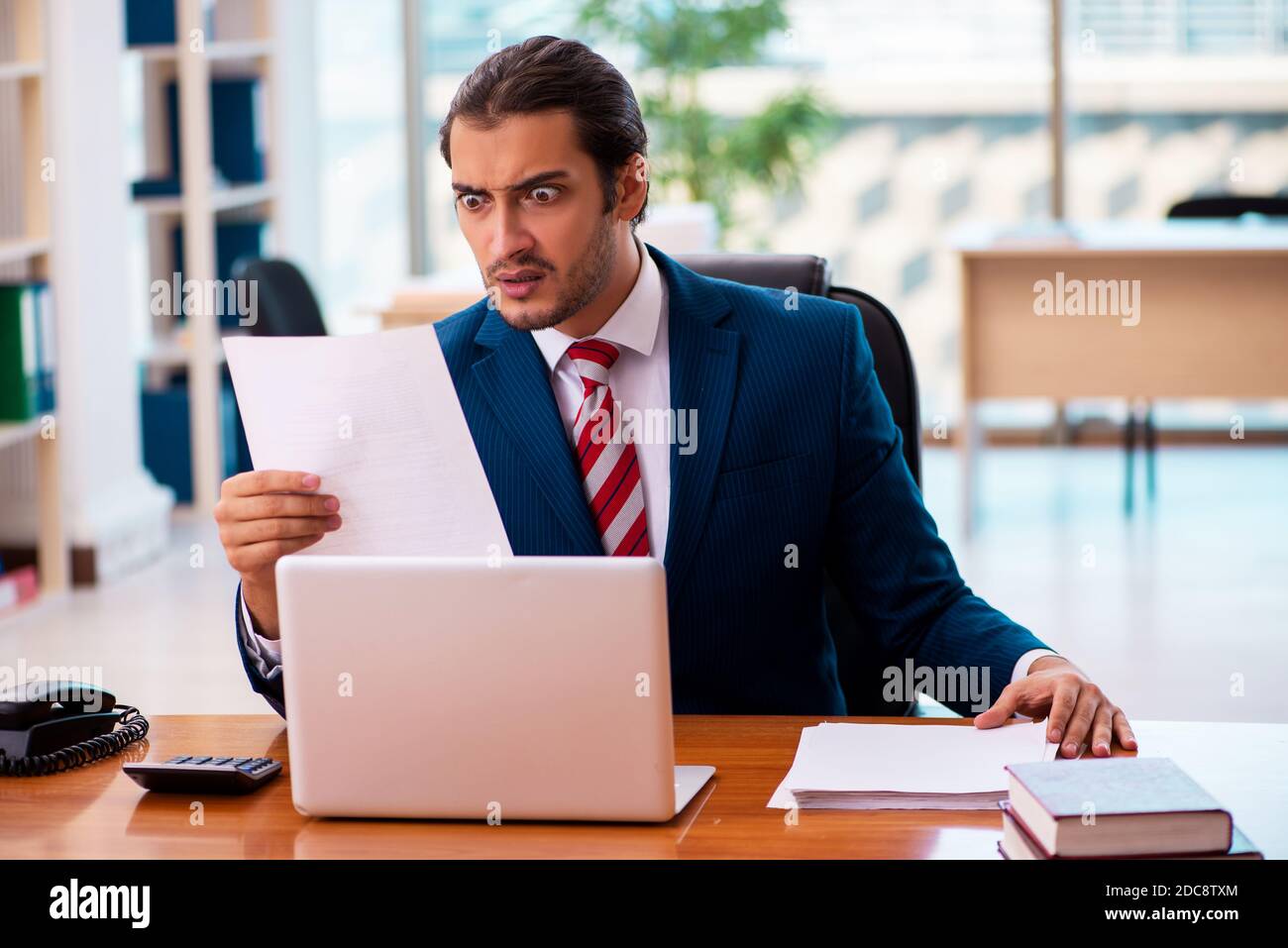 Young attractive male employee working in the office Stock Photo - Alamy