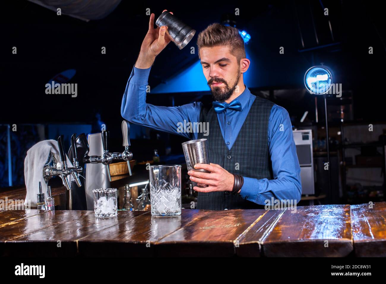 Expert Female bartender pouring fresh alcoholic drink into the glasses in the nightclub Stock ...