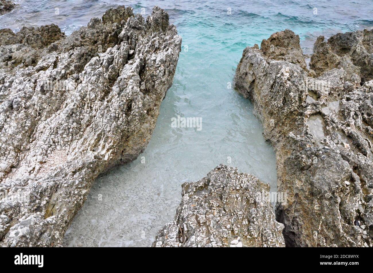 Tropical small secret pristine pebble beach surrounded by rocks ...