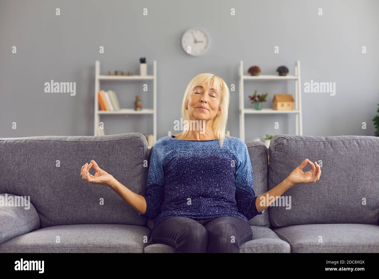 Happy relaxed senior woman practising meditation and stress relief ...
