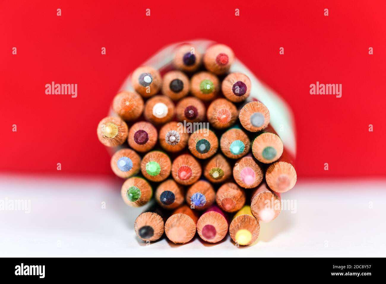 Multi-colored drawing pencils in a bundle with red background Stock ...