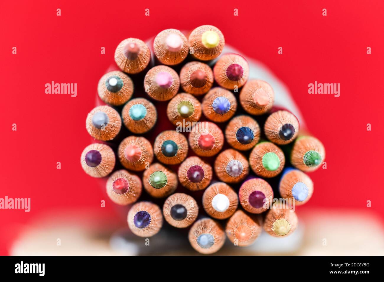 Multi-colored drawing pencils in a bundle with red background Stock ...