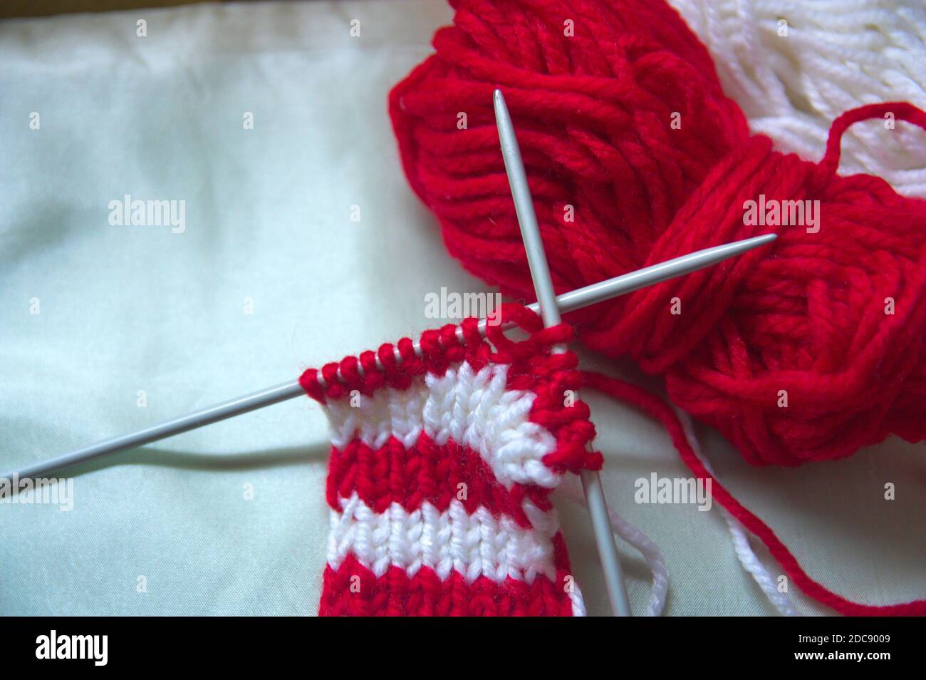 Close-up of a work in which knitting needles are used next to the balls ...