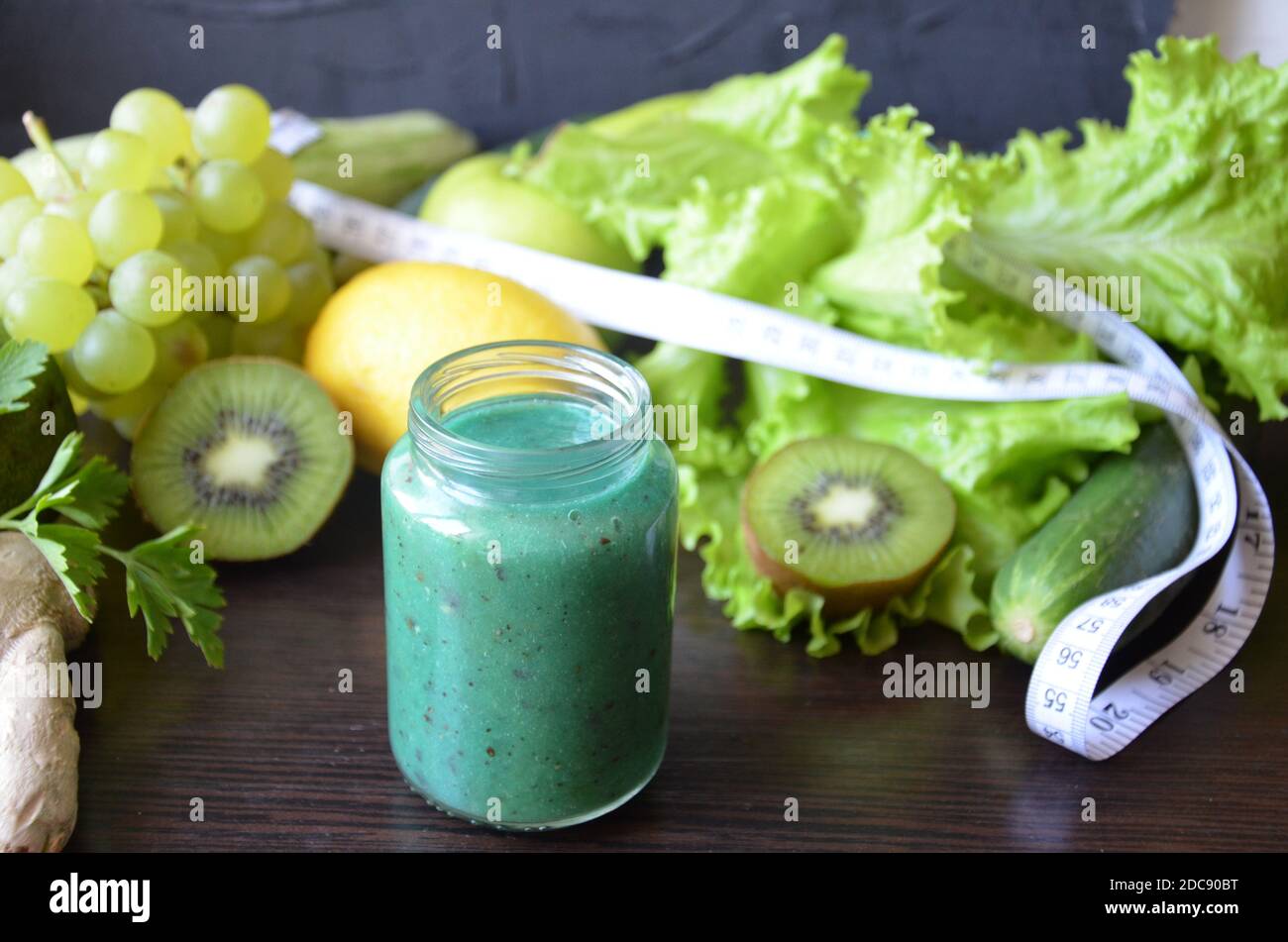 Green fruits and vegetables on a black background. Kiwi, green grapes ...