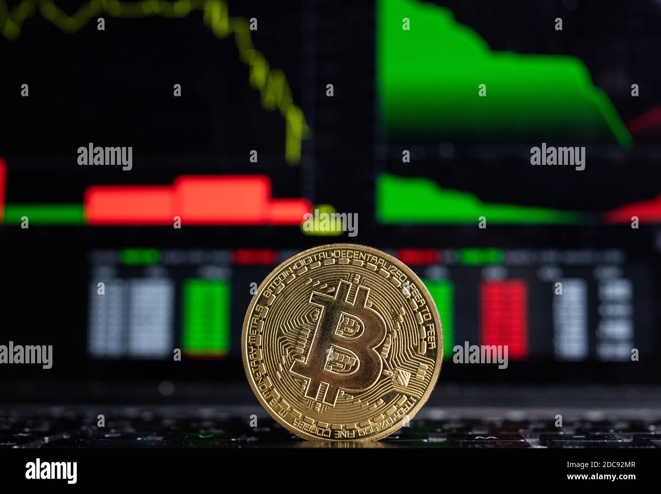 bitcoin token on computer keyboard, Bitcoin chart and price on screen ...