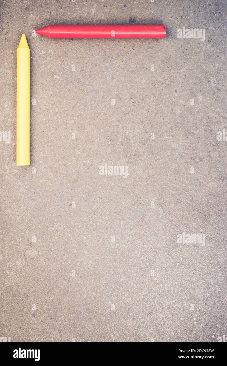 A vertical top view of red and yellow crayons on a smooth surface with ...