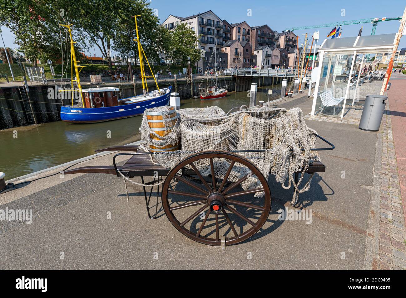 Old wooden fishing cart with crab baskets and vine barrel covered with ...