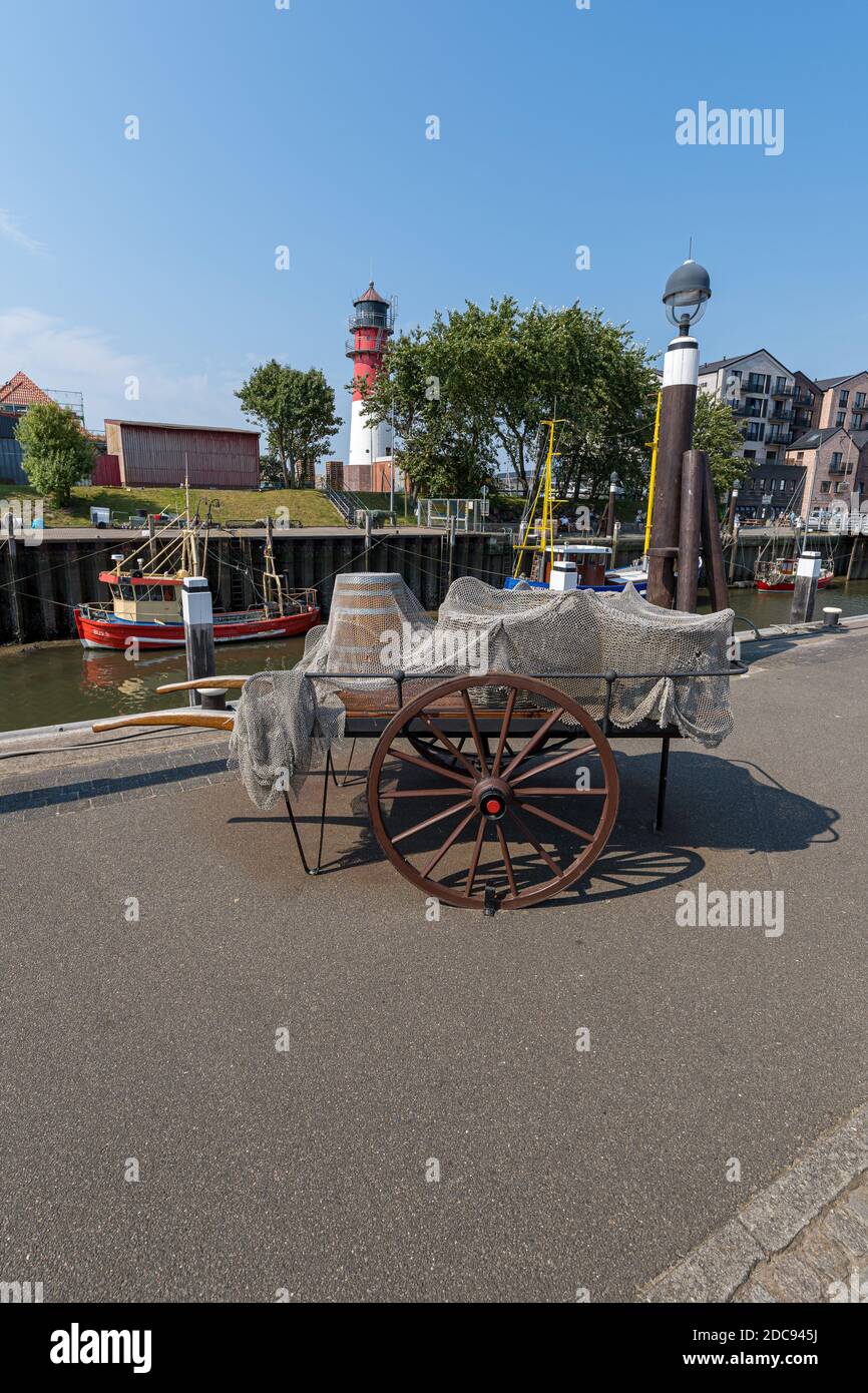 Old wooden fishing cart with crab baskets and vine barrel covered with ...