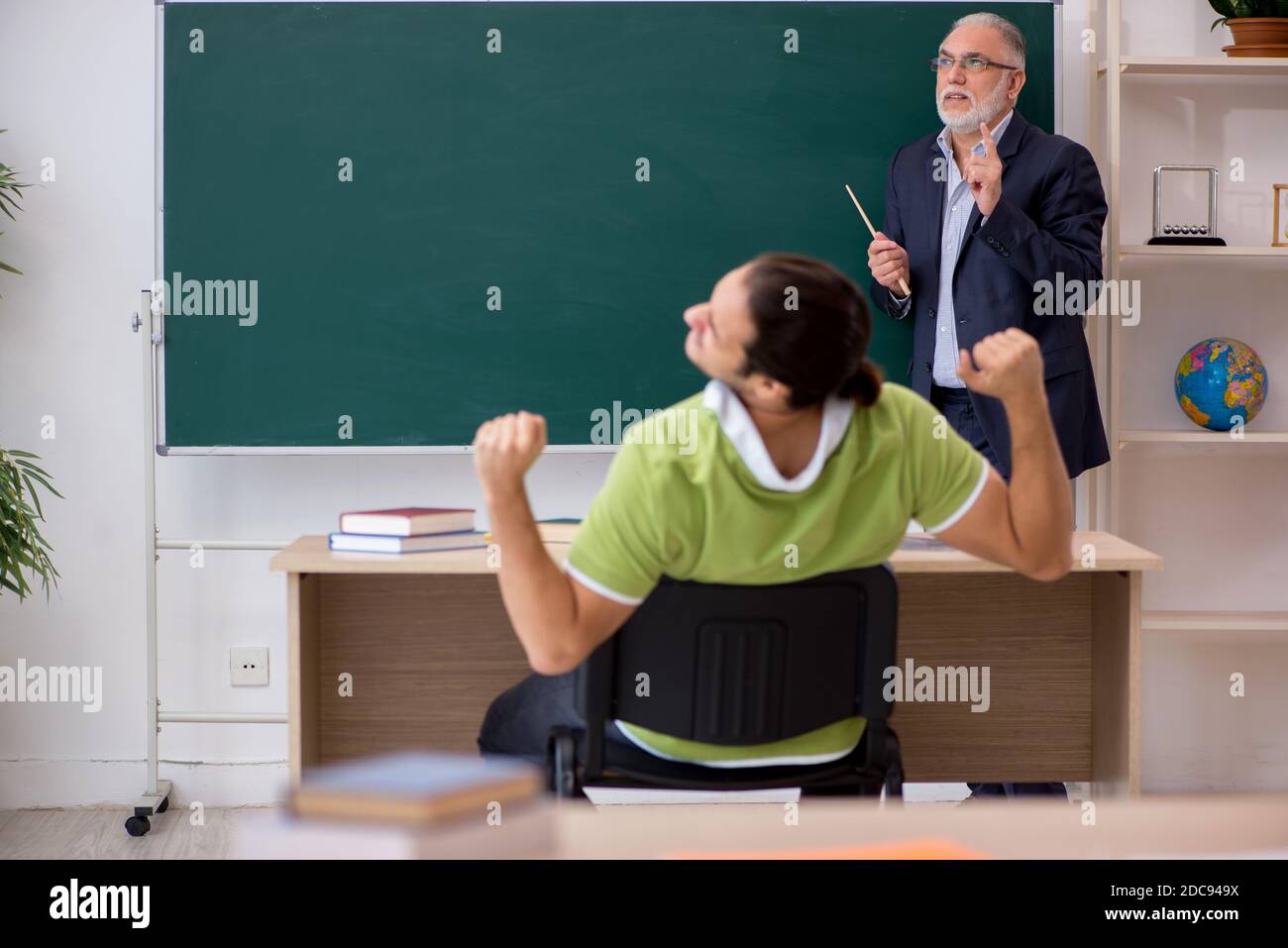 Aged male teacher and young male student in the classroom Stock Photo ...