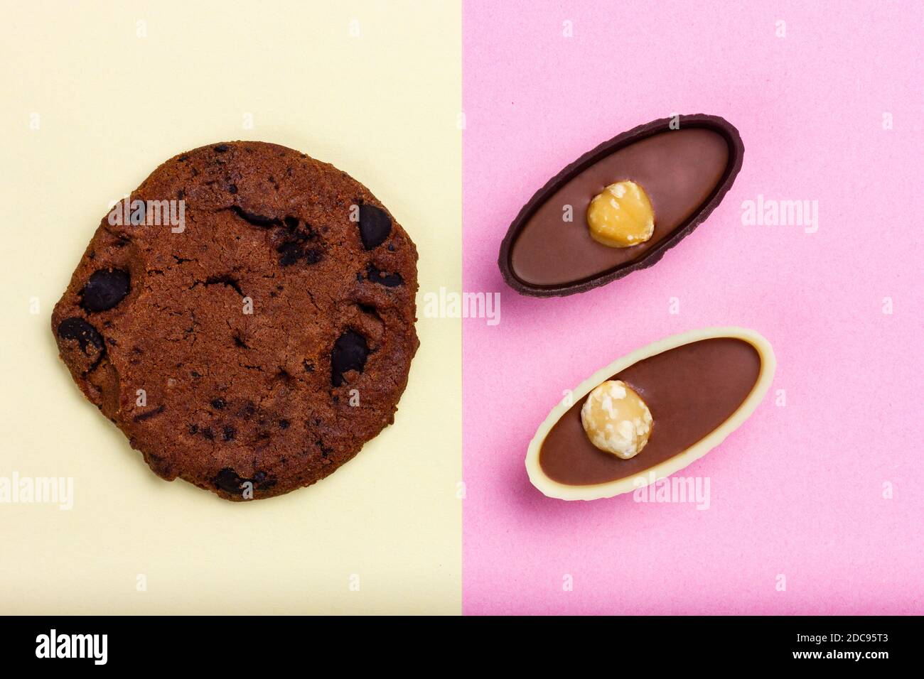 Chocolate chip cookies and chocolates with nuts on a yellow, pink ...