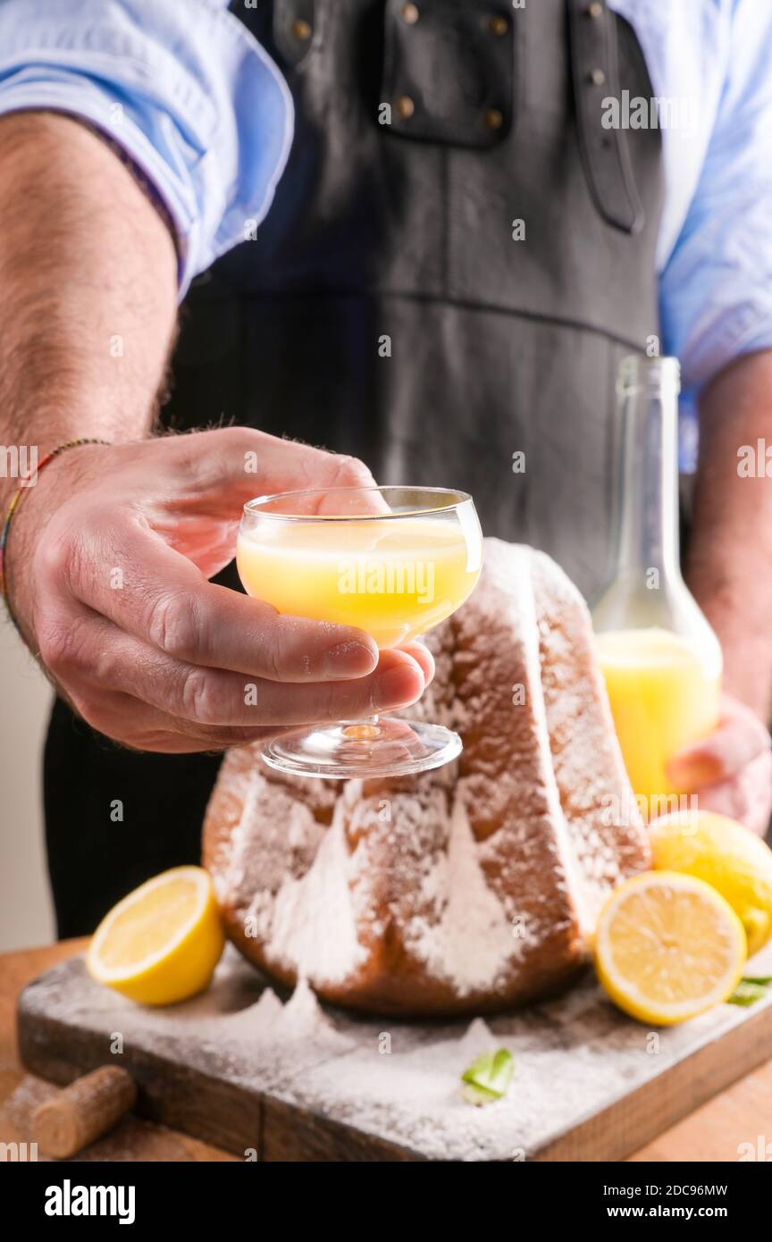 Man holds a glass of limoncello in his hands, and a soft star-shaped ...