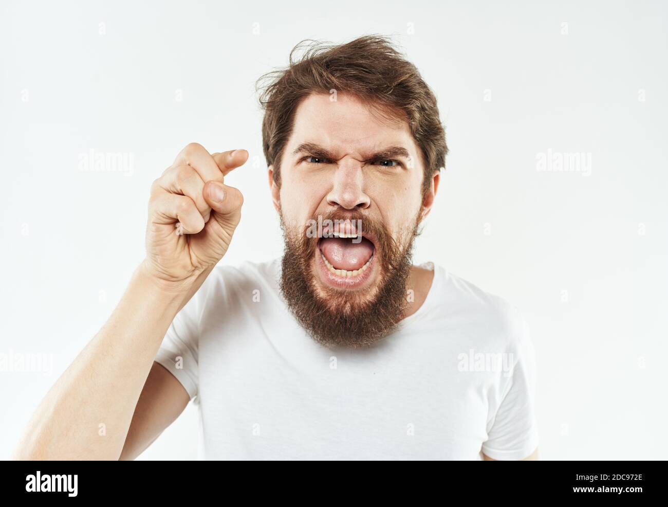 A man with a thick beard gestures irritably with his hands stress ...