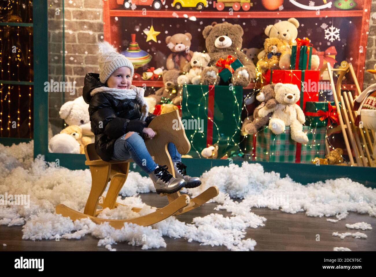 Happy child riding rocking horse near toy shop Stock Photo - Alamy