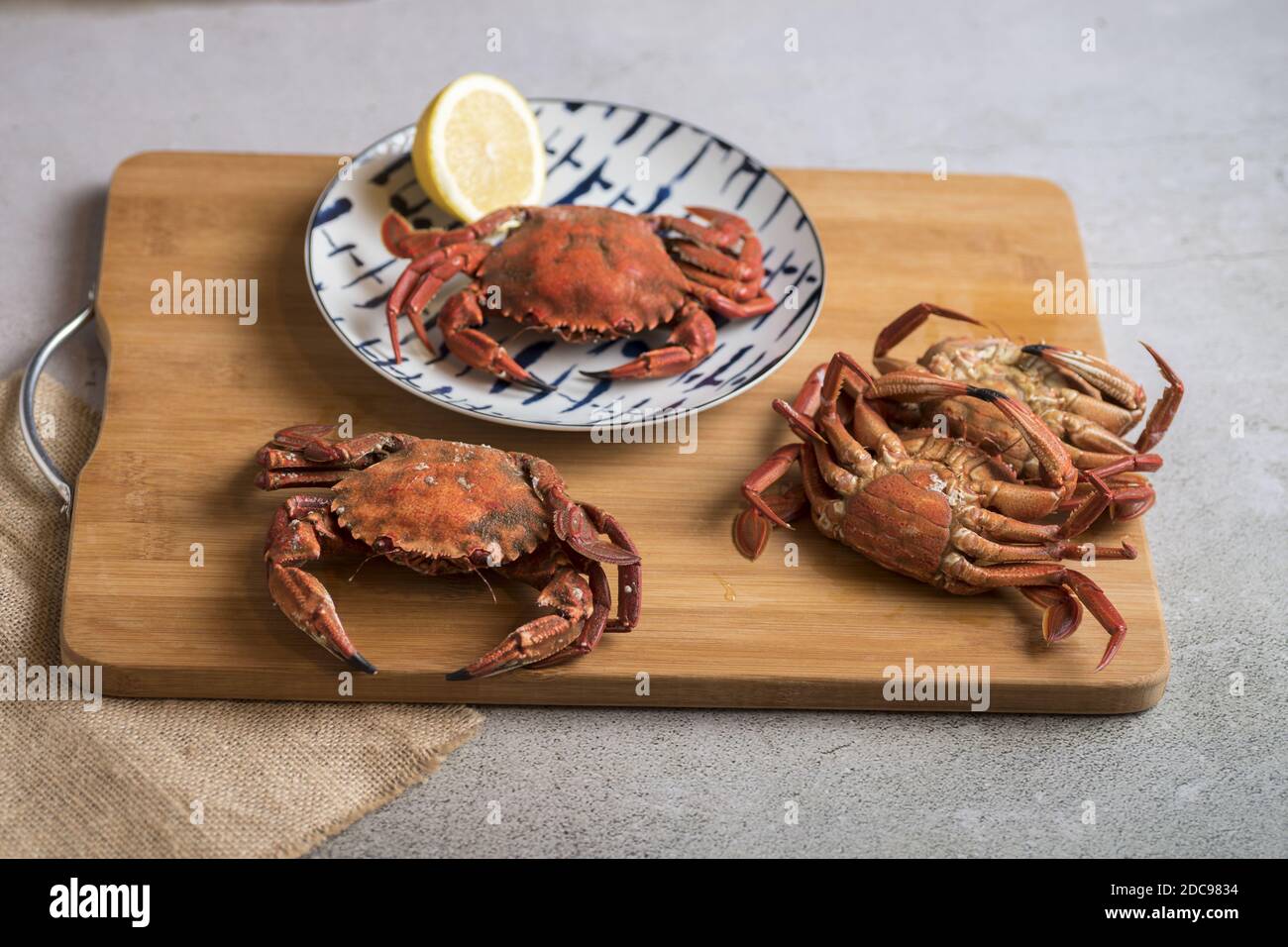 The deliciously cooked crabs on plates with lemons and herbs Stock ...
