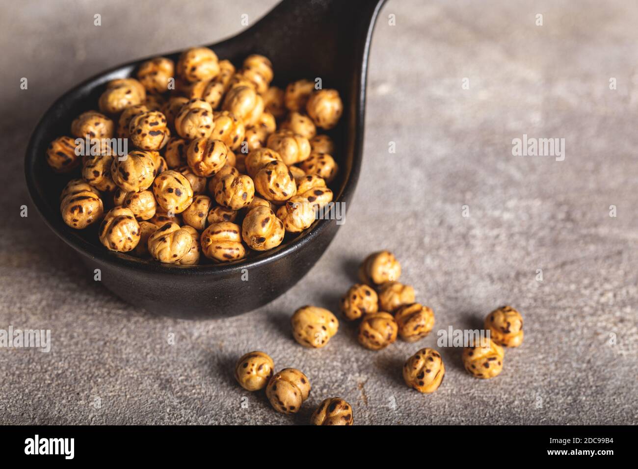 Roasted, yellow chickpeas in black bowl on stone background (Turkish ...