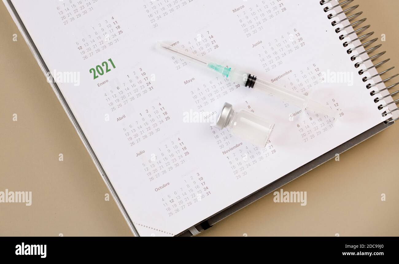 syringe and vaccine with calendar 2021, light brown background Stock ...