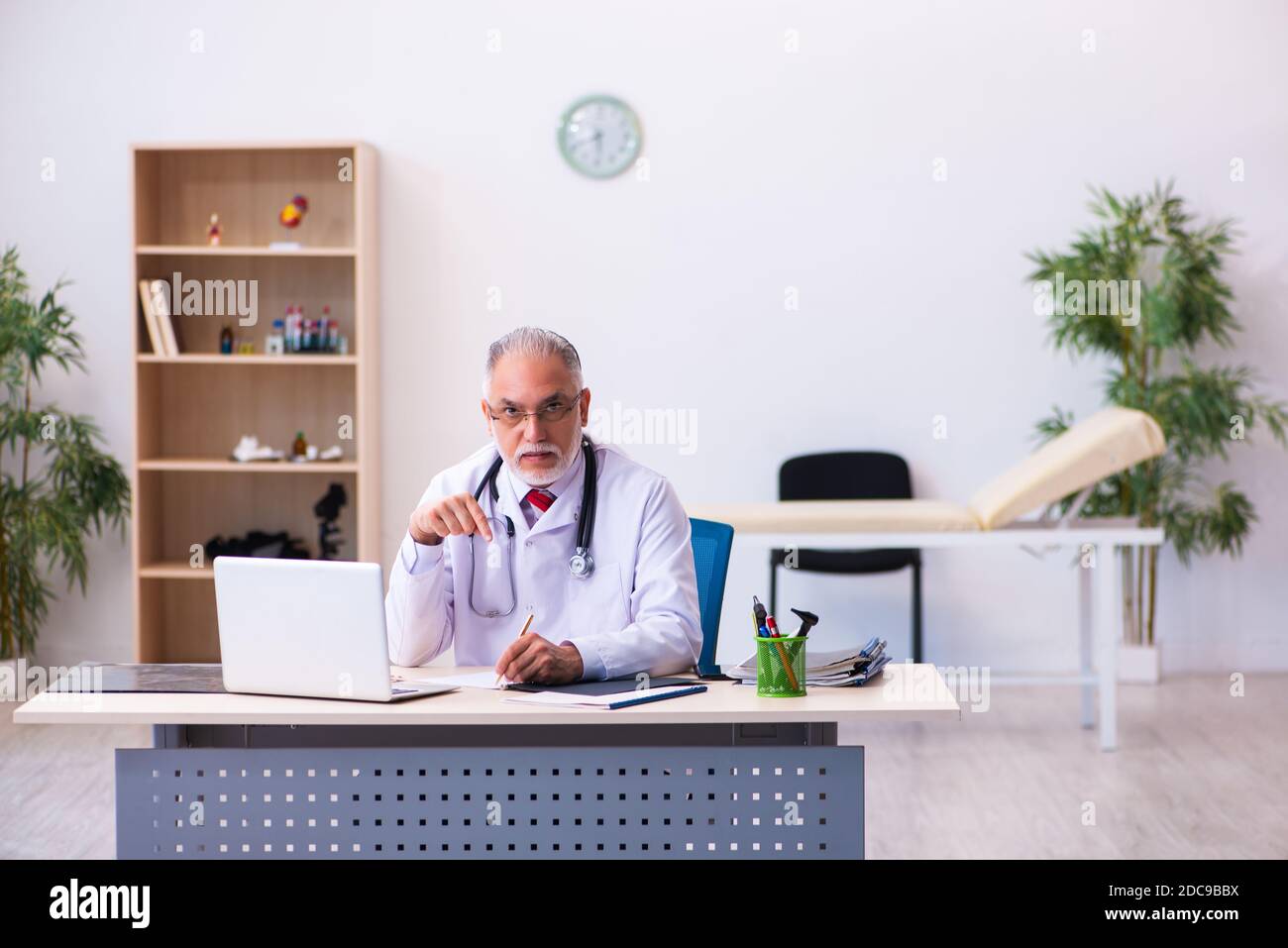 Old doctor working in the clinic Stock Photo - Alamy