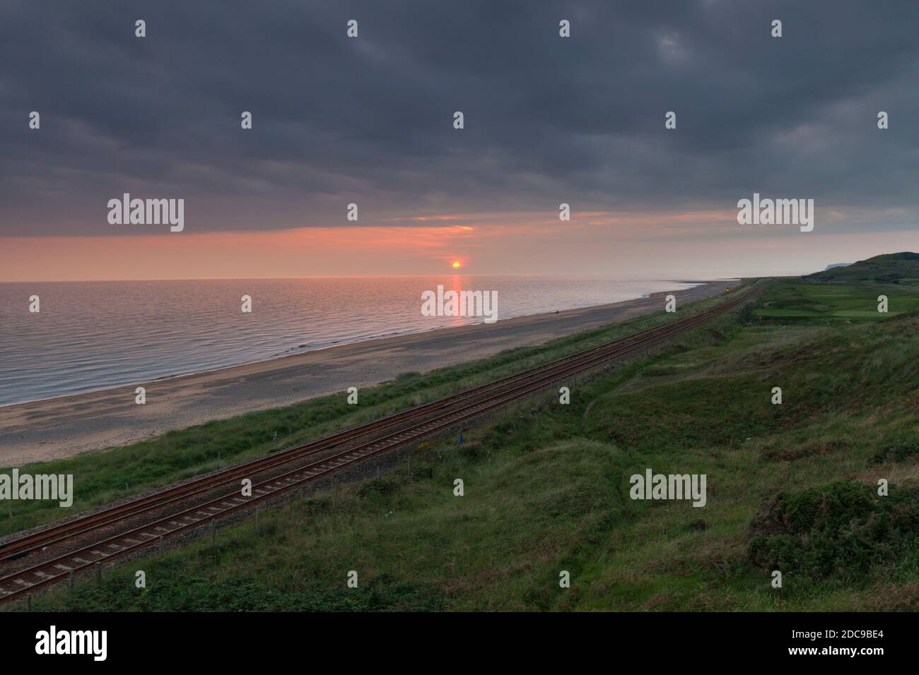 Sunset on the Cumbrian coast railway line looking towards the beach at ...