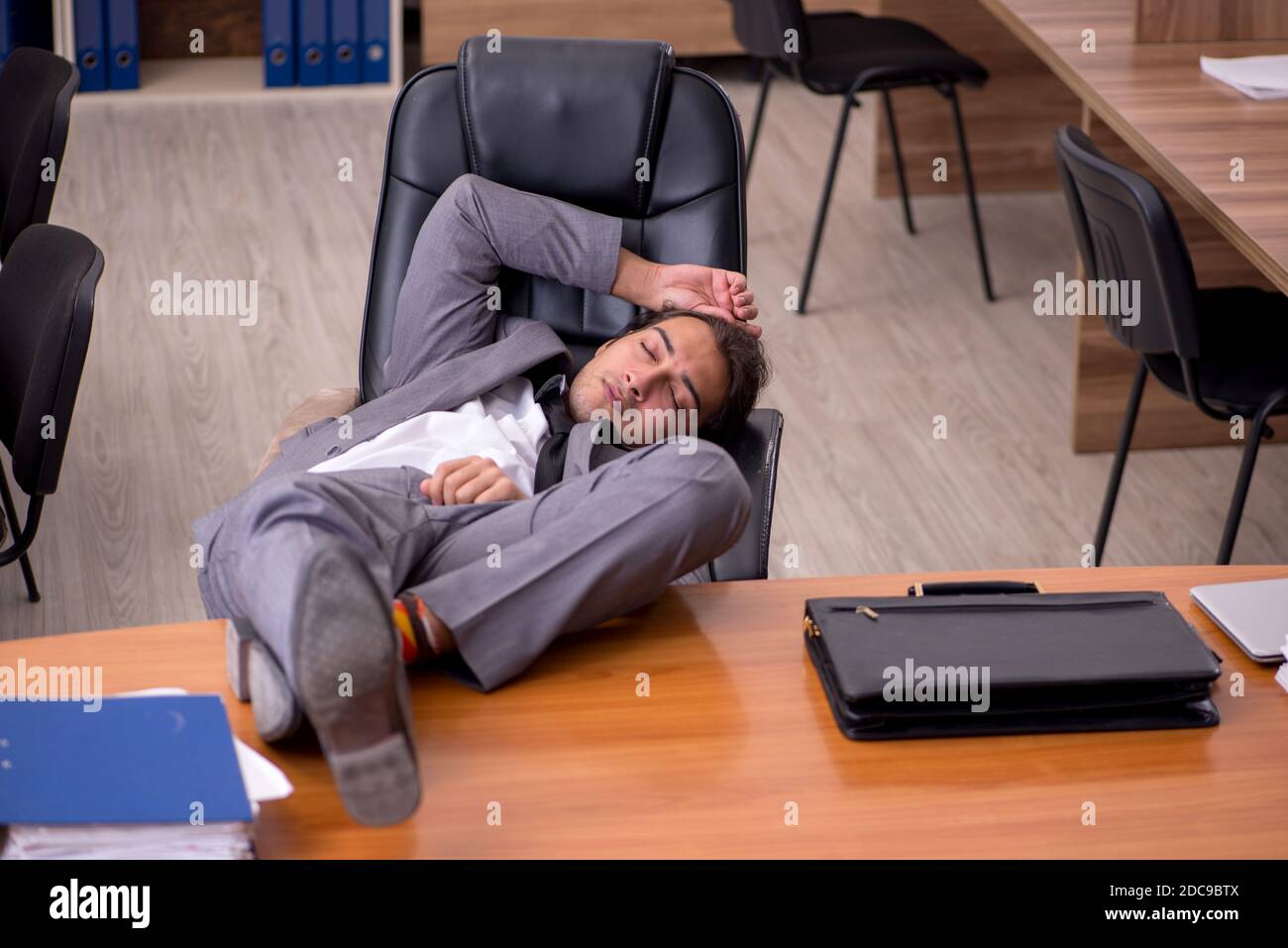 Young employee sleeping at workplace Stock Photo - Alamy