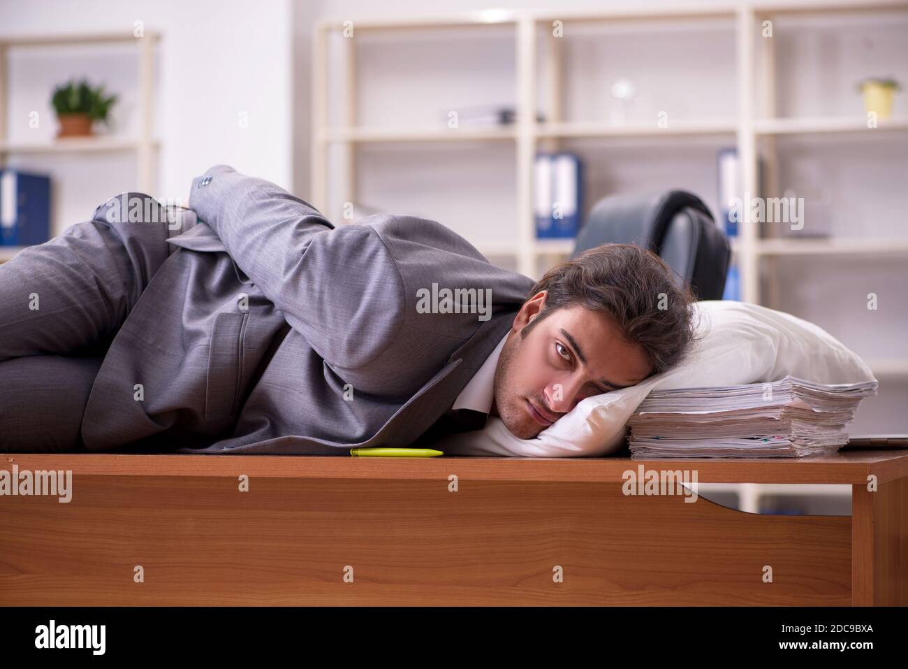 Young employee sleeping at workplace Stock Photo - Alamy