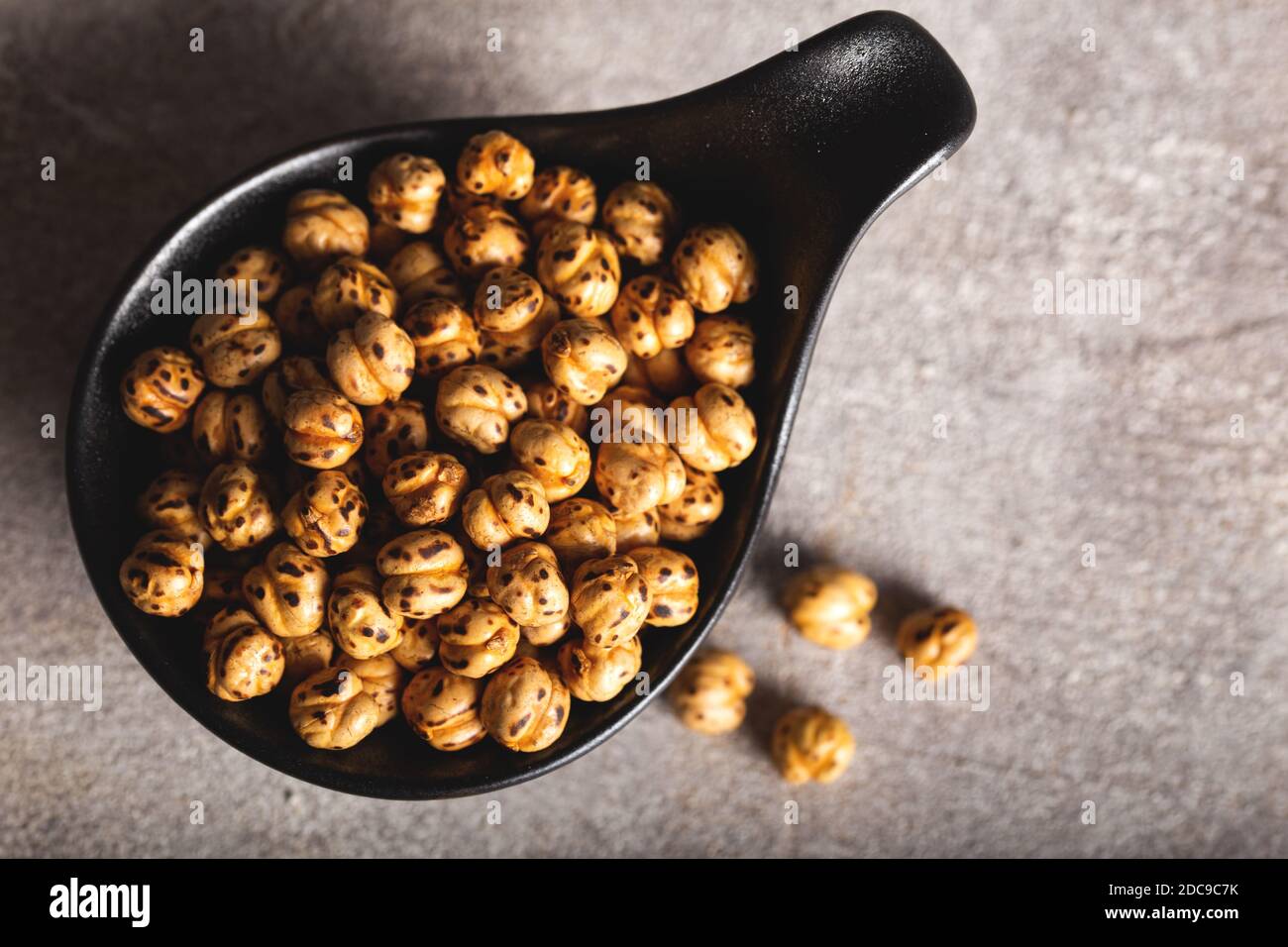 Roasted, yellow chickpeas in black bowl on stone background (Turkish ...