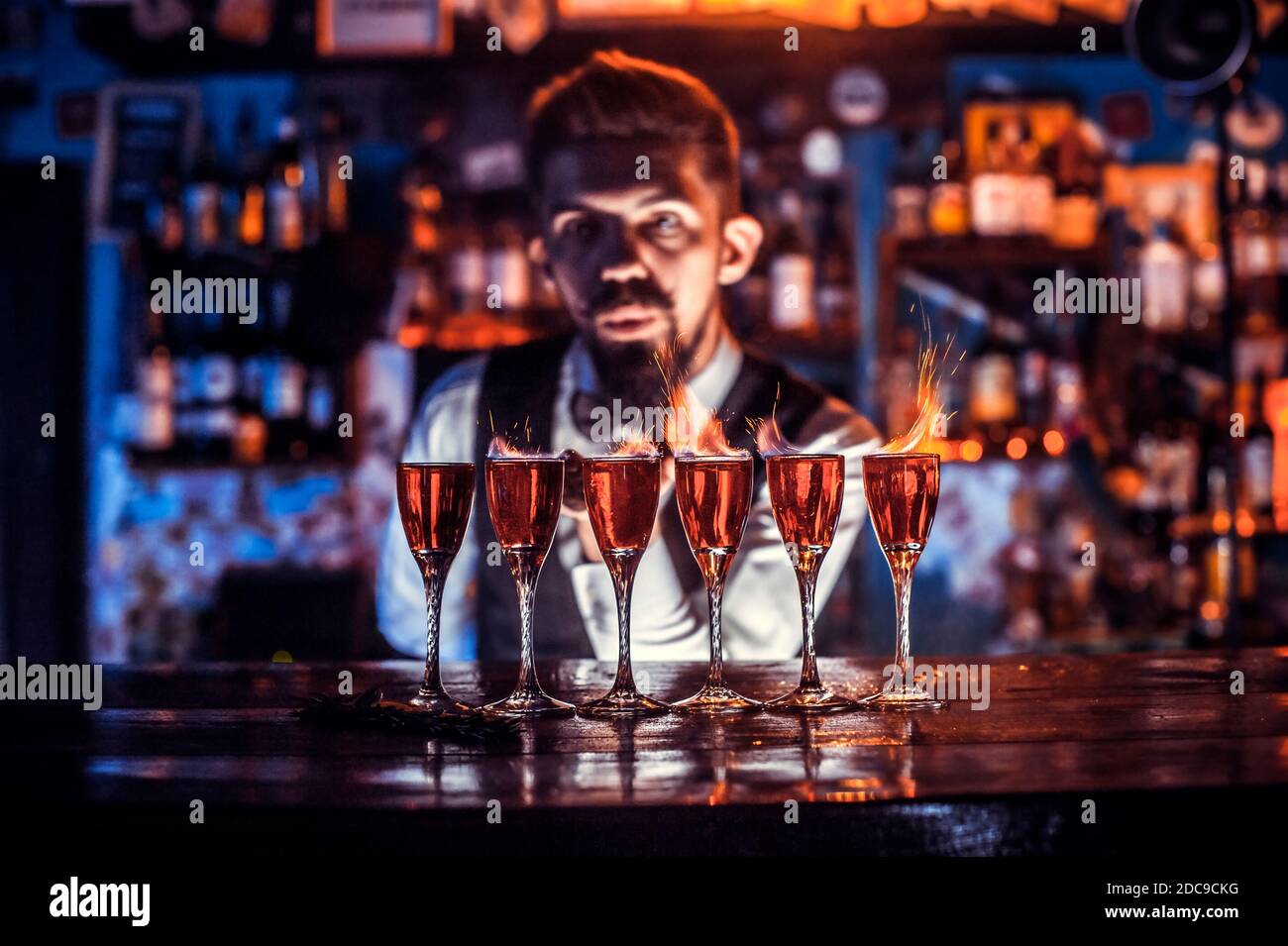 Portrait of bartender demonstrates the process of making a cocktail ...