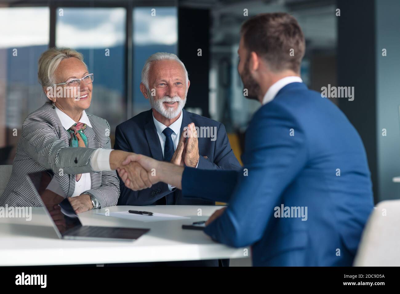 Positive aged couple consulting with insurance agent Stock Photo - Alamy