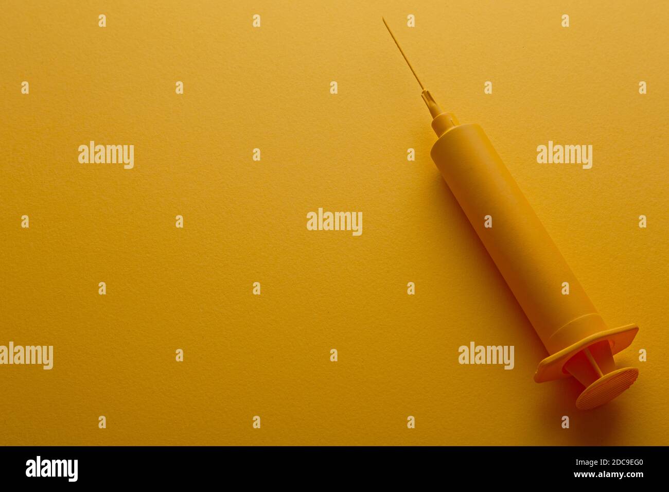 Yellow injection syringe on yellow background Stock Photo - Alamy