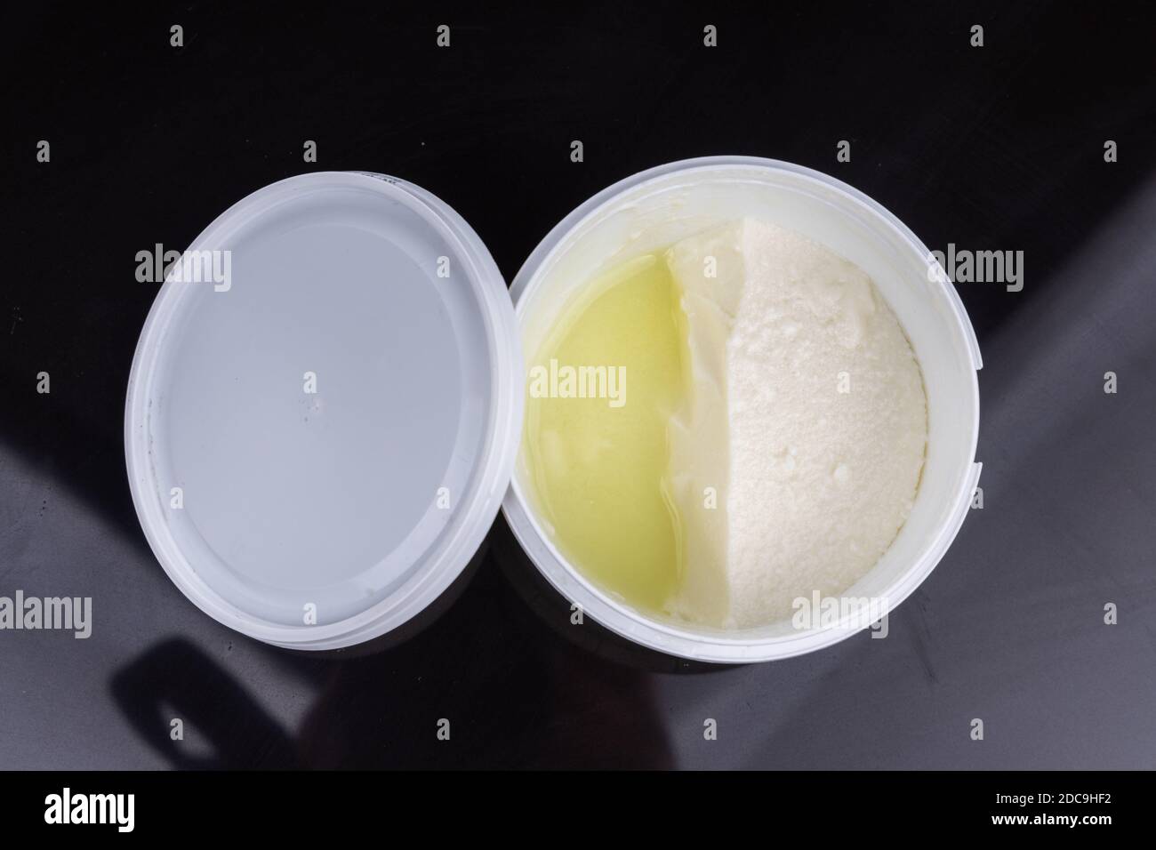 Layer of whey protein formed on top of packaged yogurt after opening in ...