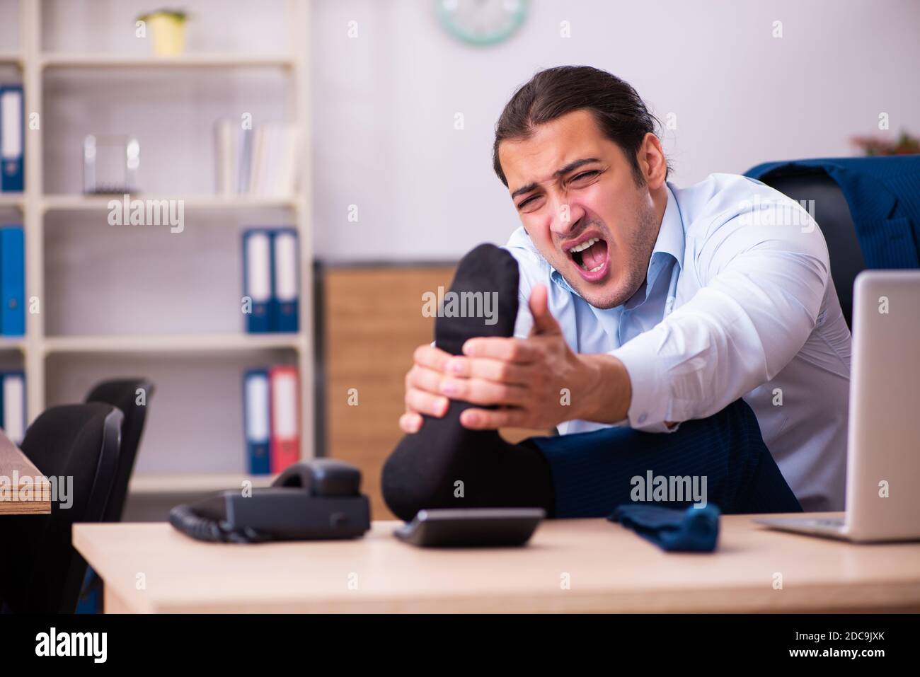 Young employee doing physical exercises at workplace Stock Photo - Alamy