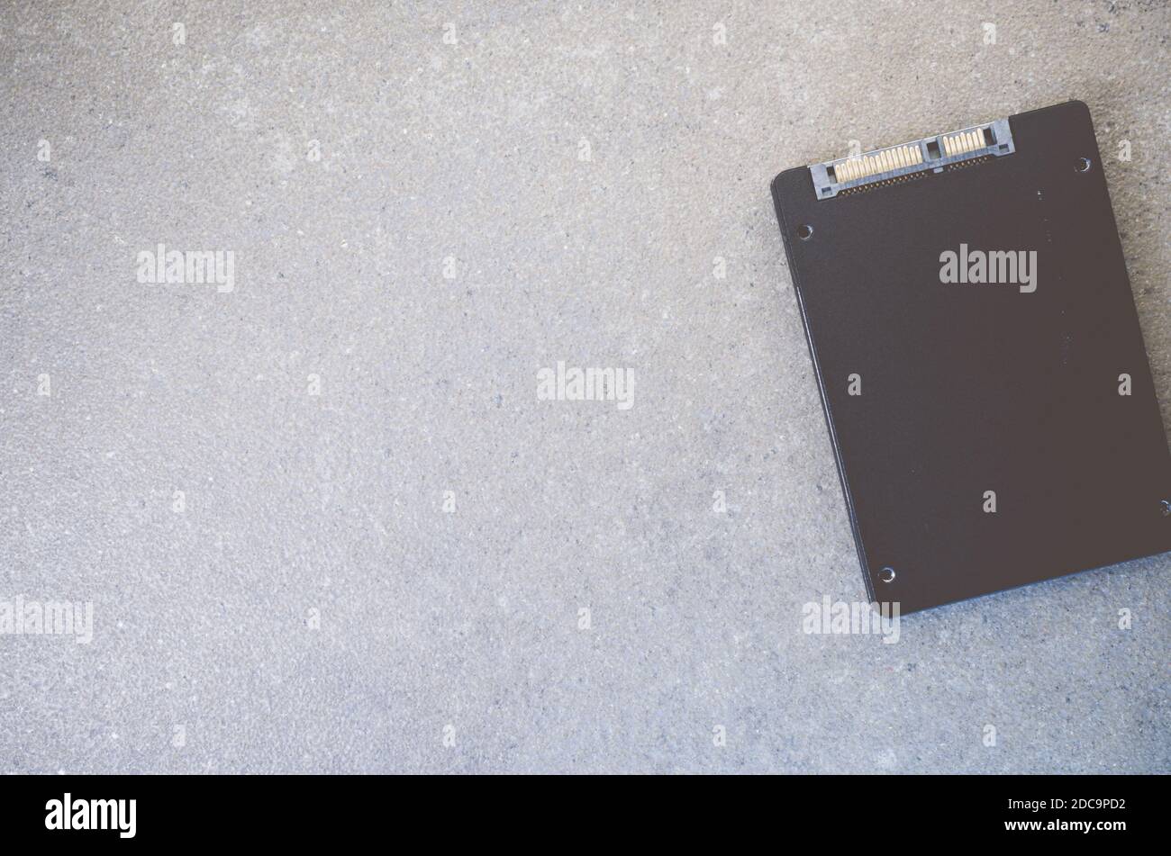 A top view of solid-state drive on a rough textured background with ...