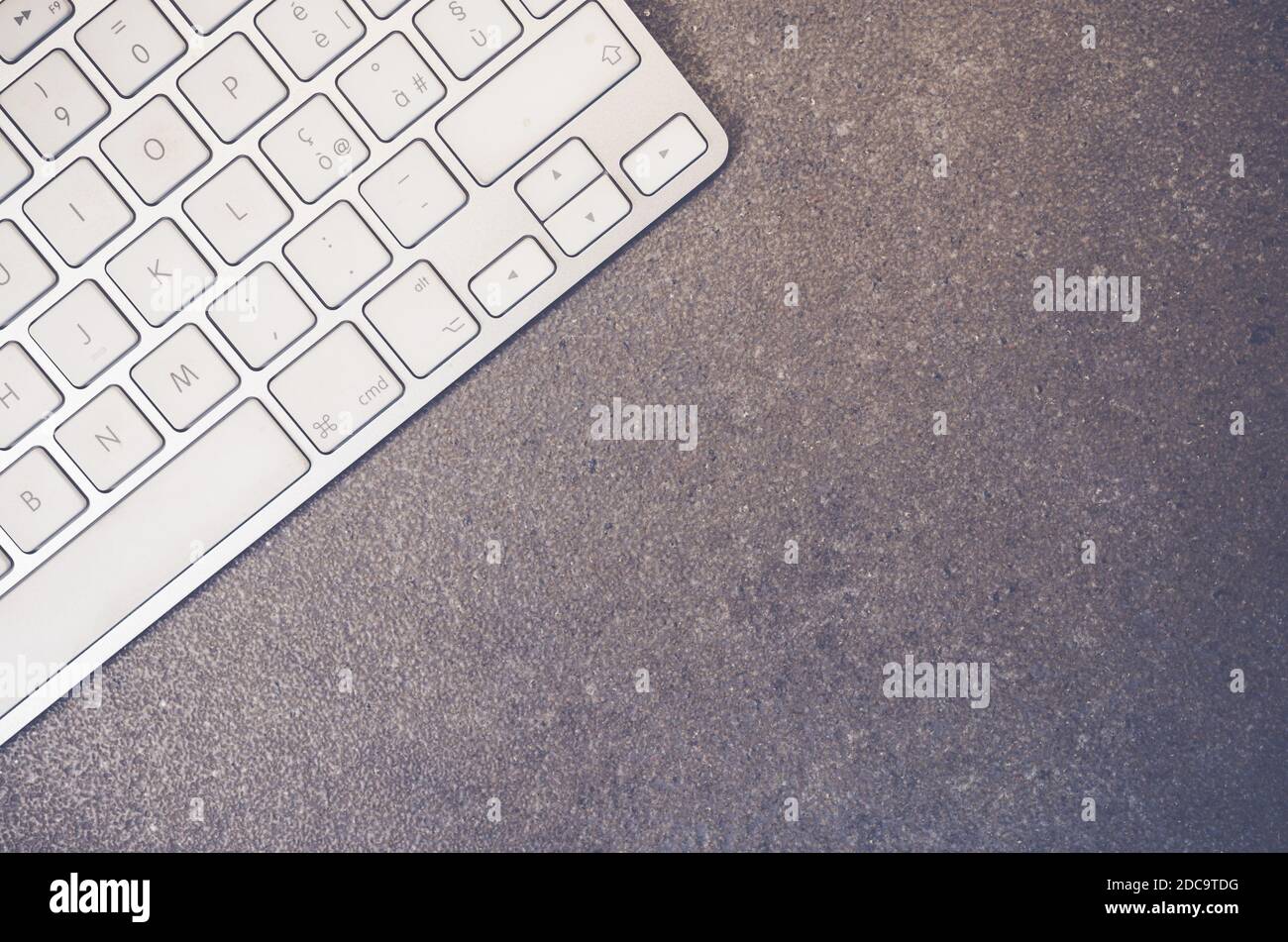 A top view of a computer keyboard on a stone textured surface with copy ...