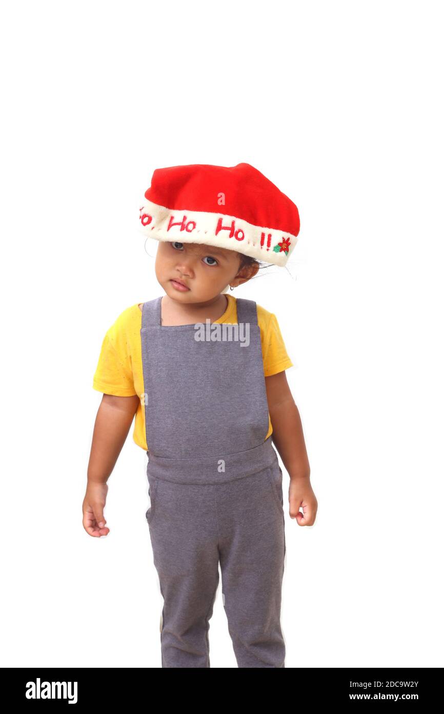 Adorable asian little girl standing while wearing santa's hat ...