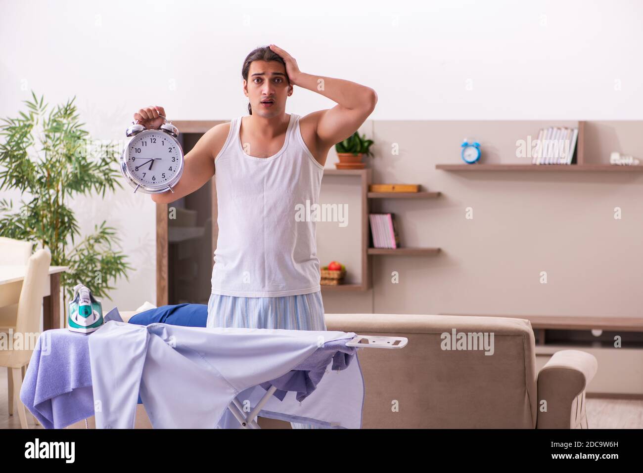 Young employee getting up late at home Stock Photo - Alamy