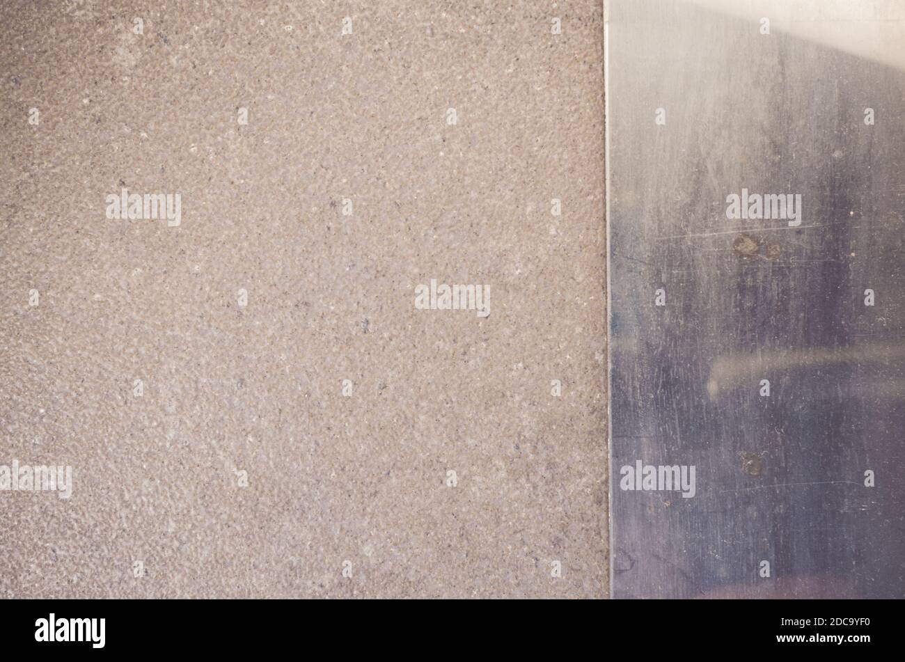 A top view of plain steel plate on a rough-textured surface with copy ...