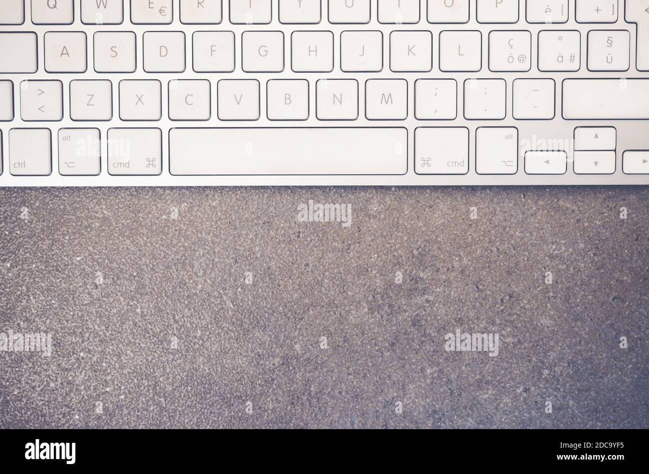 A top view of a computer keyboard on a stone textured surface with copy ...