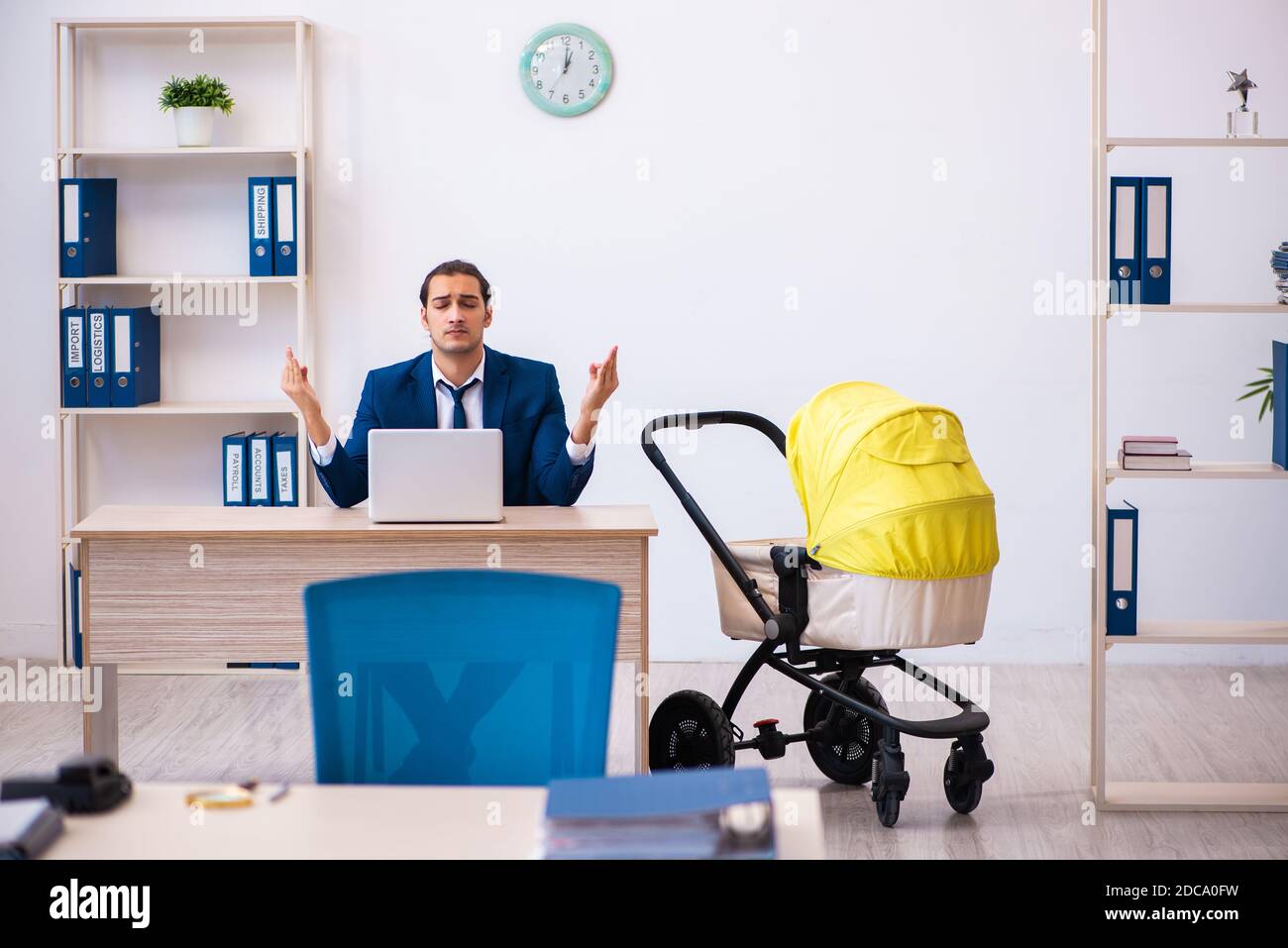 Young employee looking after kid at workplace Stock Photo - Alamy