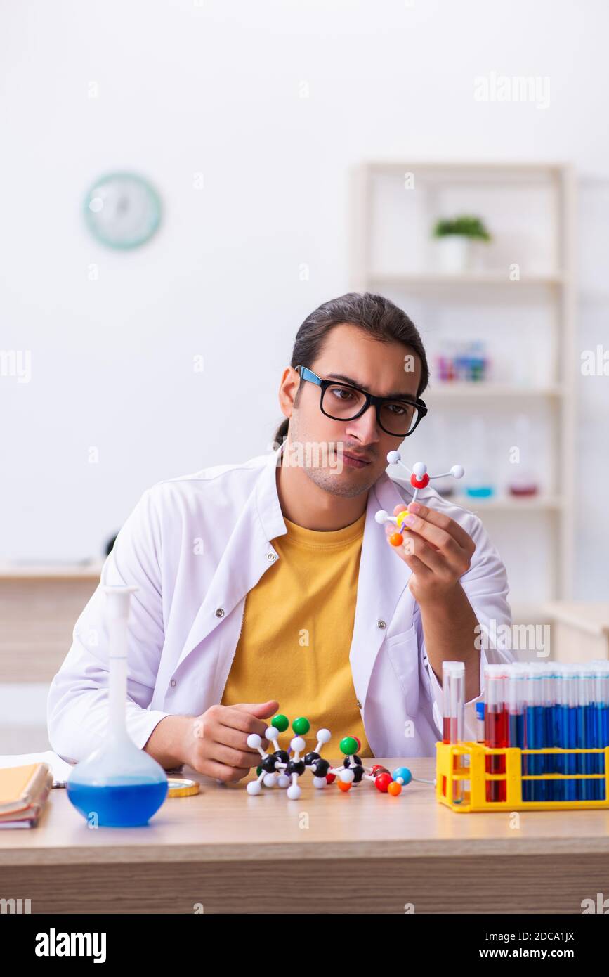 Young chemist studying molecular model in the classroom Stock Photo - Alamy