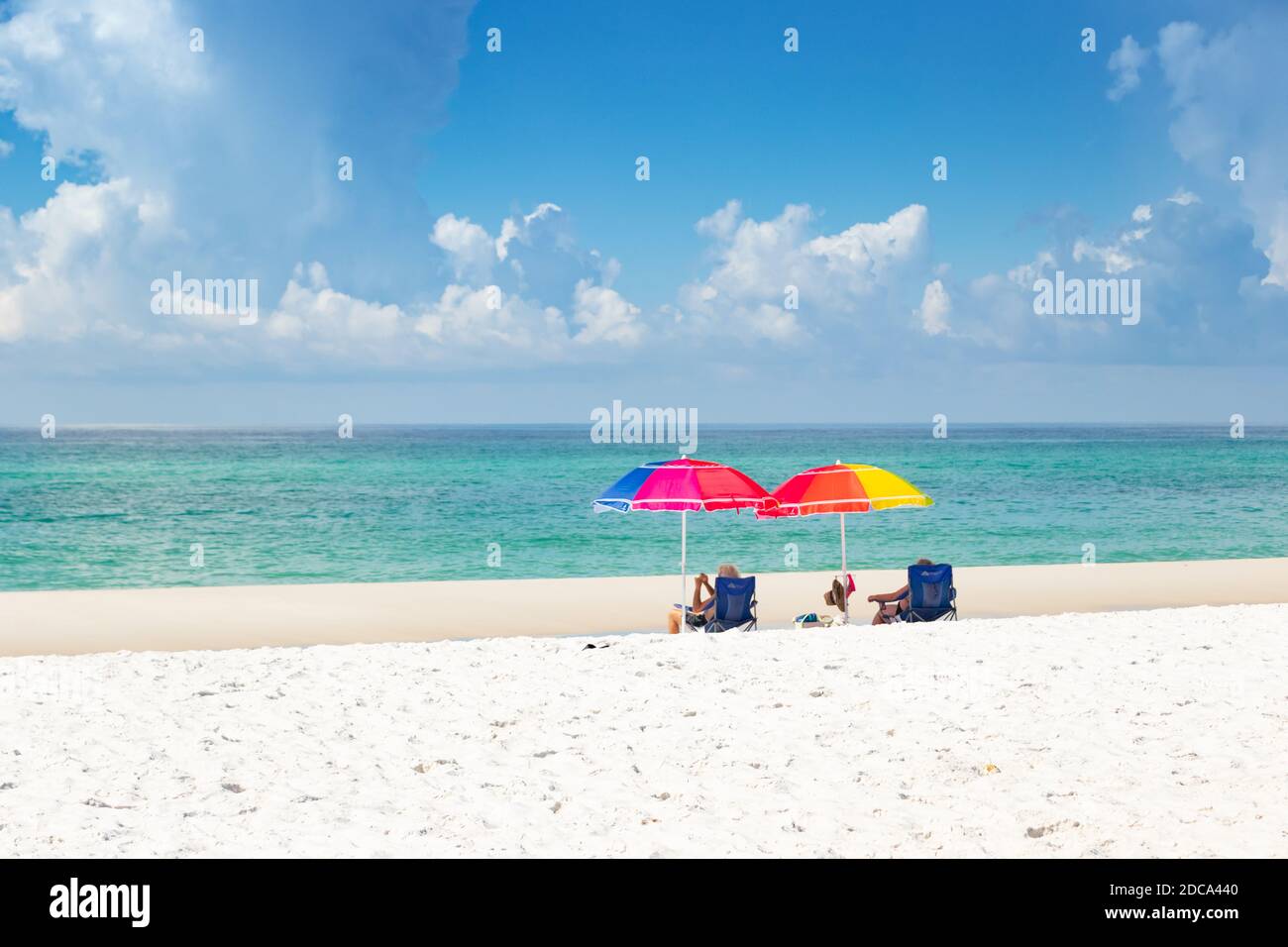 two isolated colourful rainbow sun parasol shade with sand and sea at ...