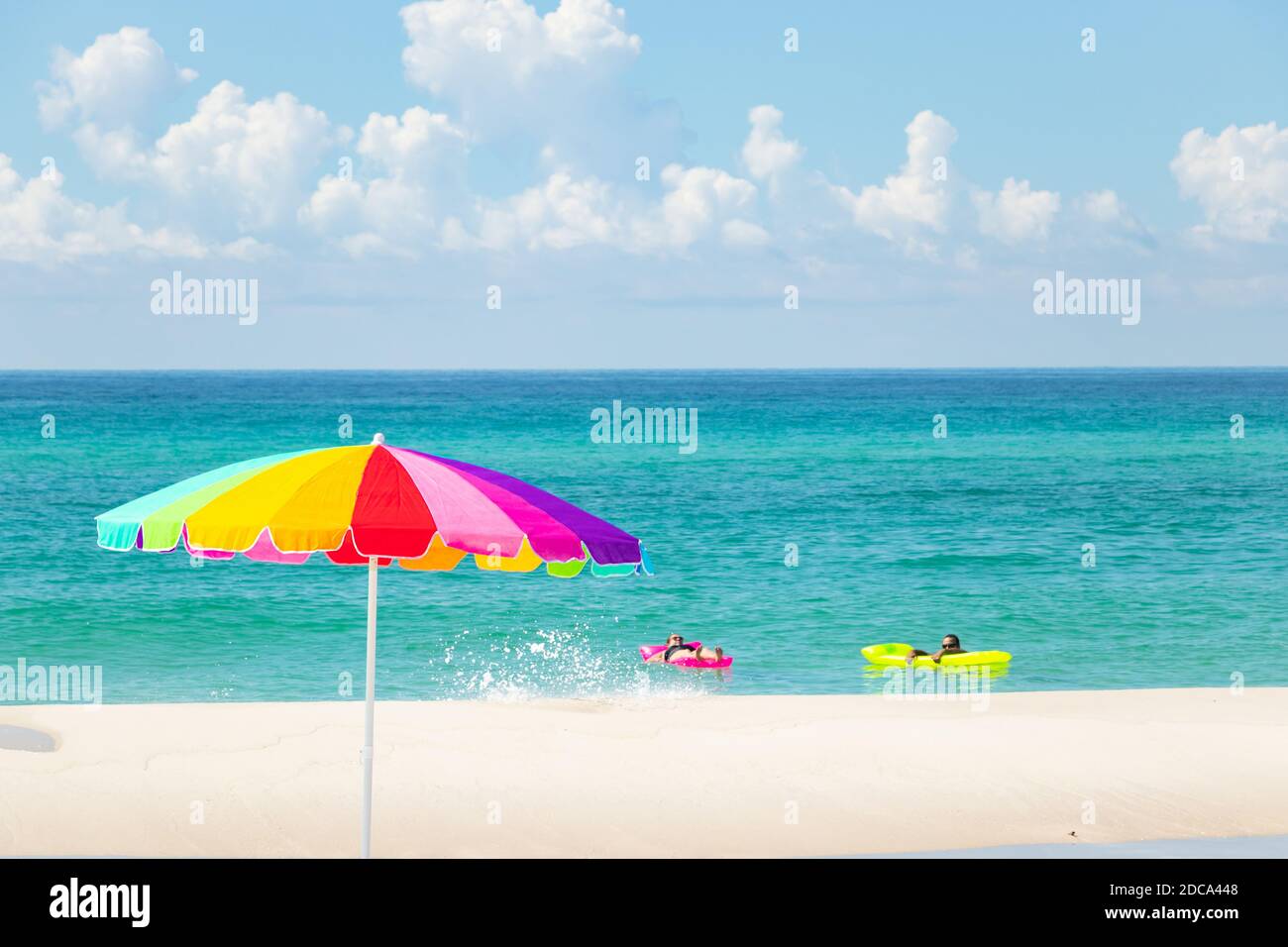 isolated colourful rainbow sun parasol shade with sand and sea at beach ...
