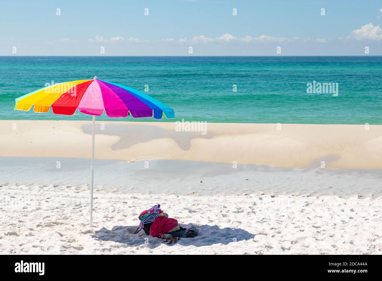 isolated colourful rainbow sun parasol shade with sand and sea at beach ...