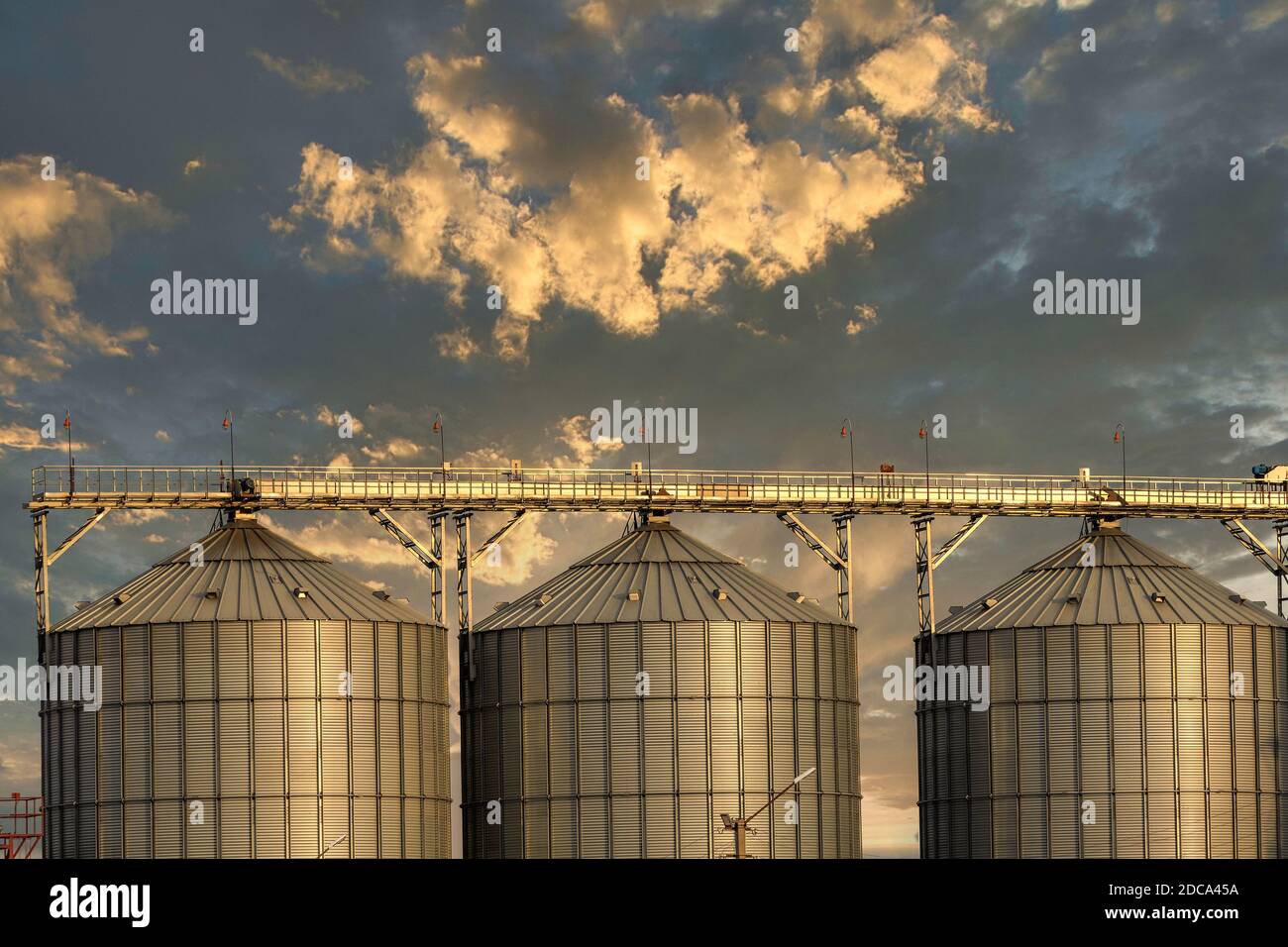 Low angle shot of grain storage units. Beautiful sunset sky background ...