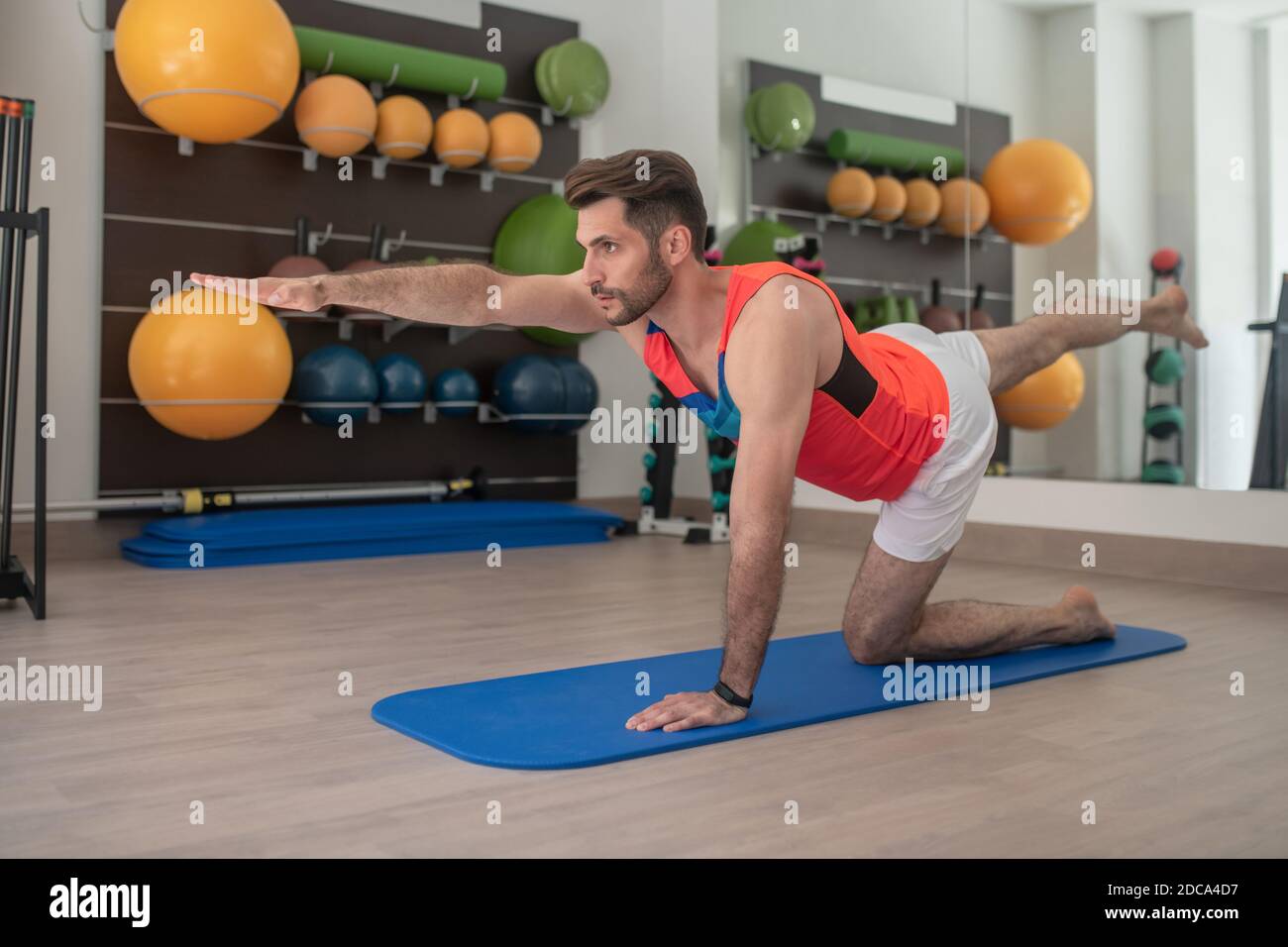 Bearded young male practising bird dog exercise Stock Photo - Alamy