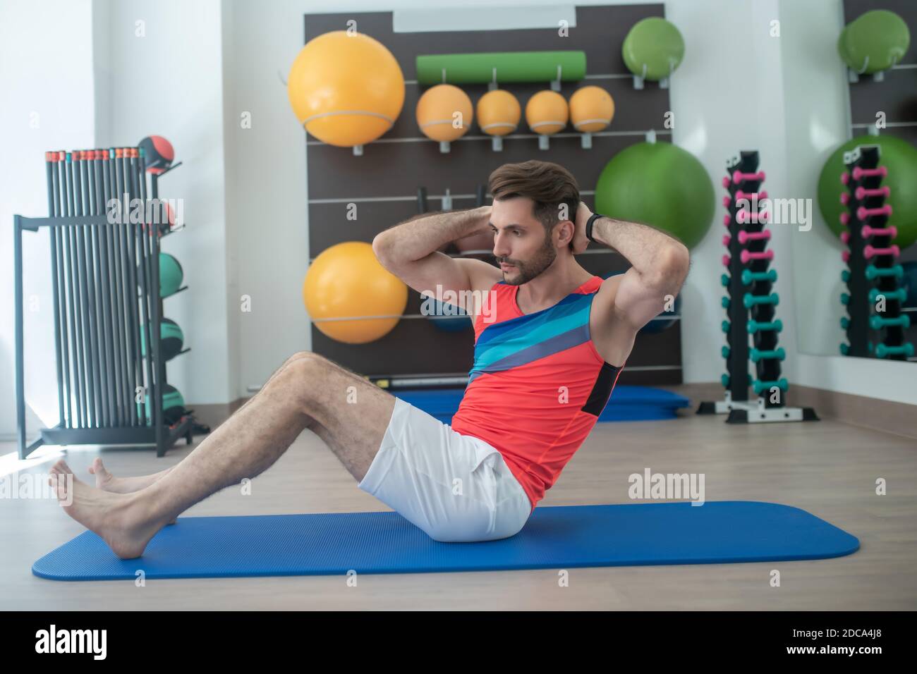 Bearded young male doing sit-ups on the blue mat Stock Photo - Alamy