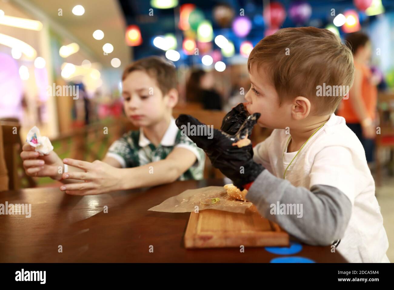 Portrait of kid eating Cheeseburger in restaurant Stock Photo - Alamy