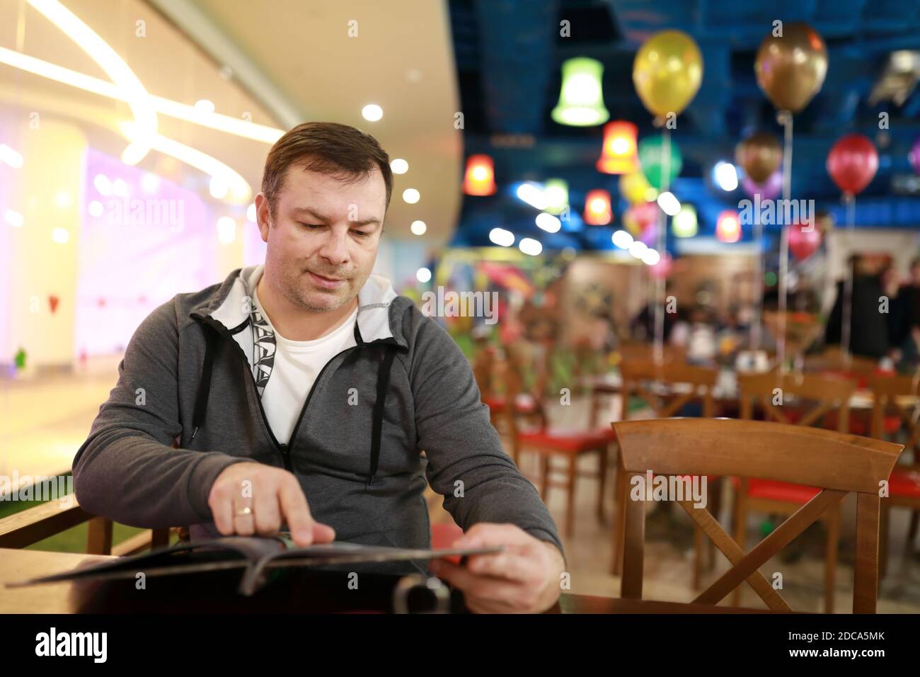 Man choosing food in menu in restaurant Stock Photo - Alamy