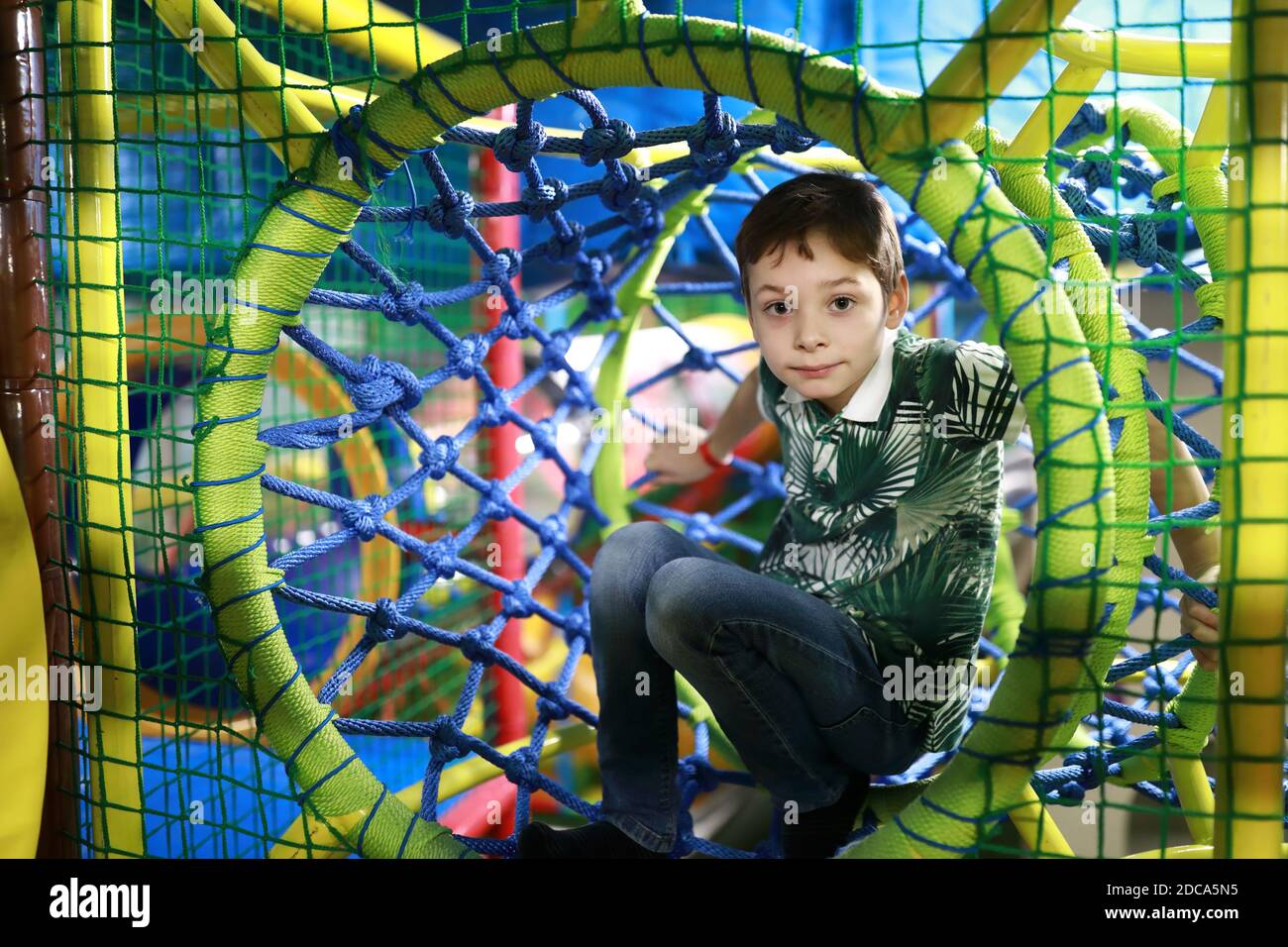 Kid in rope maze on indoor playground Stock Photo - Alamy