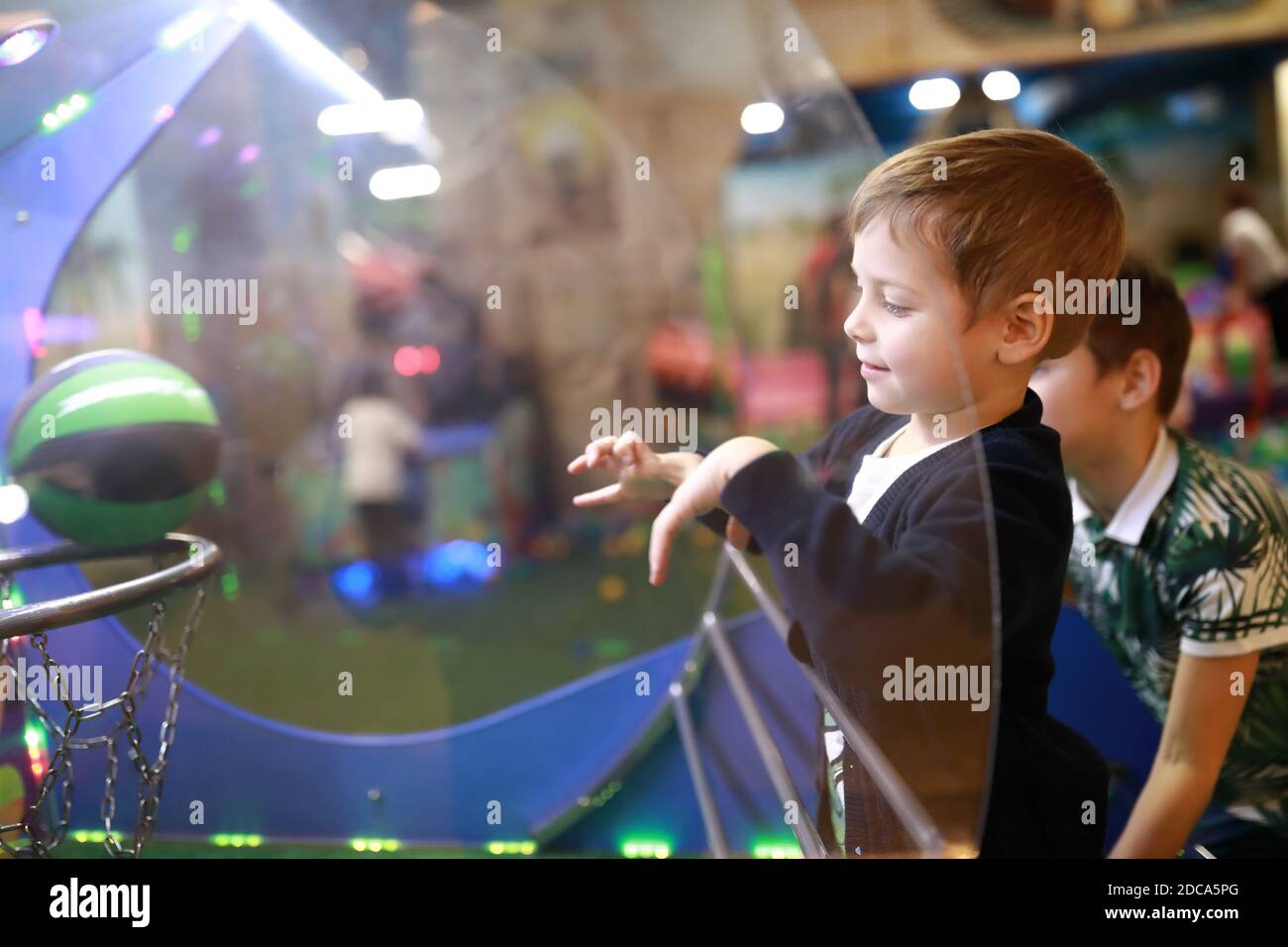 Child throws ball into ring on playground Stock Photo - Alamy