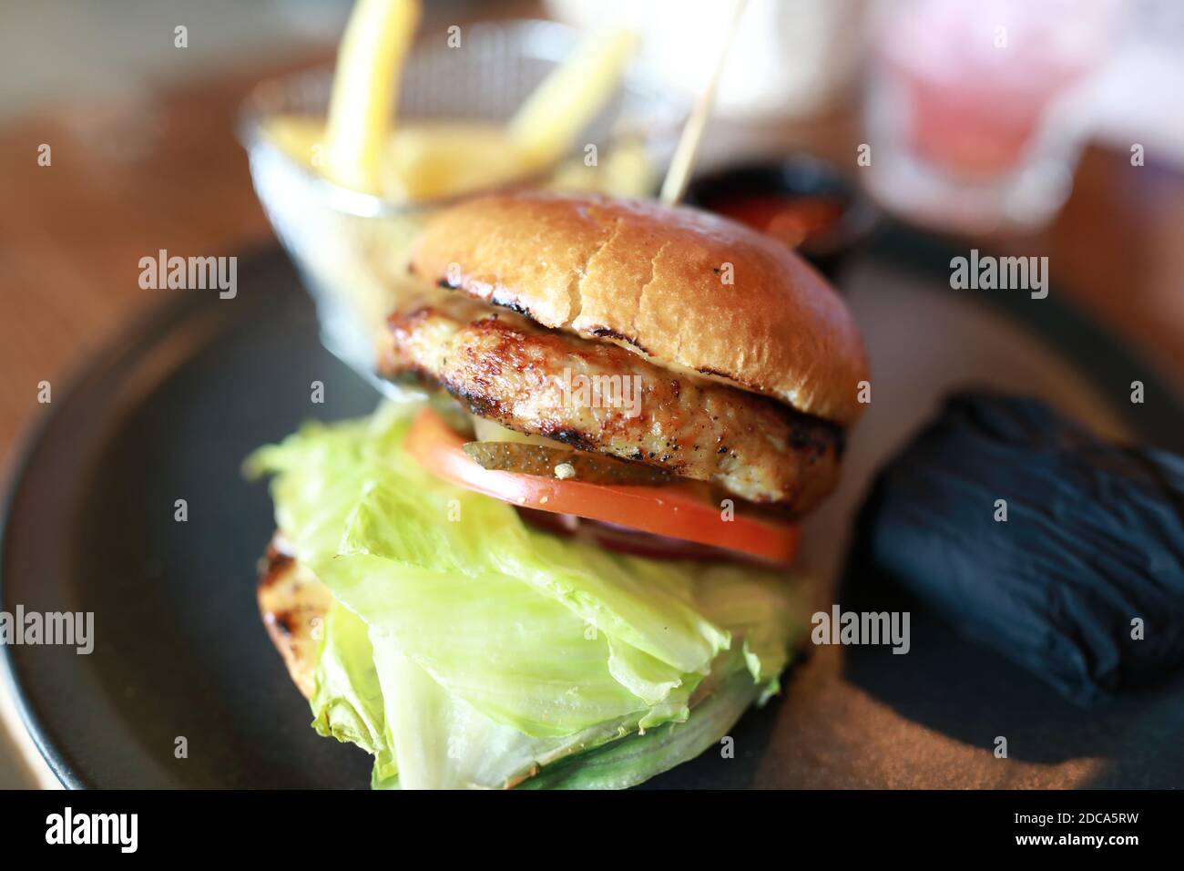 Chicken cutlet burger on plate in restaurant Stock Photo - Alamy